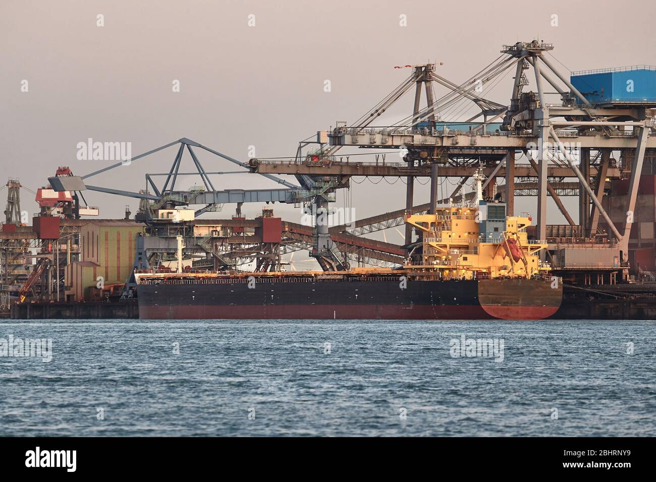 Industrial harbor with rusty structures, bulk carrier ship Stock Photo ...