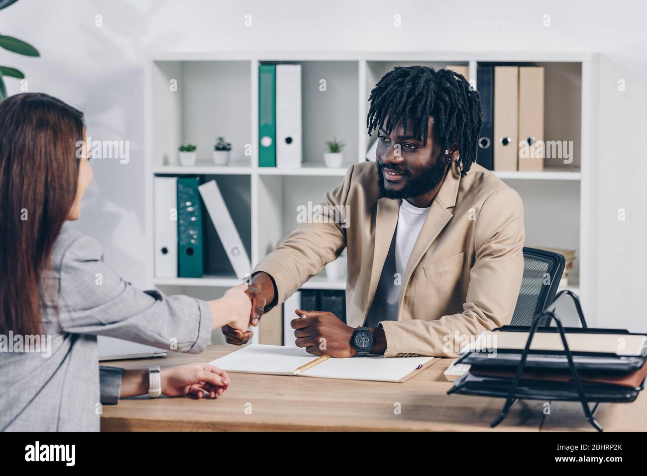 African american recruiter shaking hands with employee at job interview ...