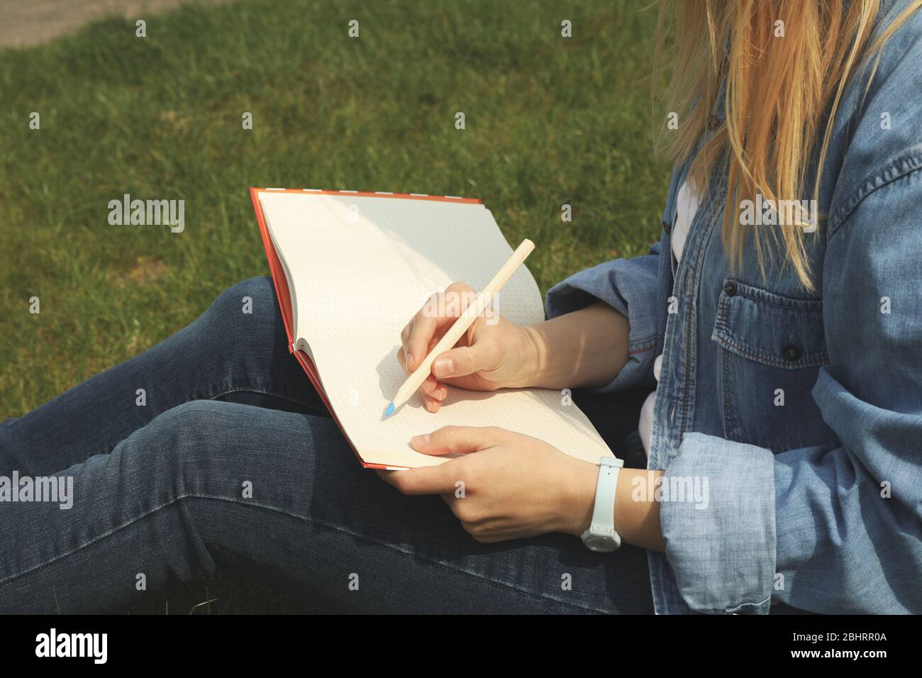 Girl draws outdoor sitting on green grass. Creativity concept Stock ...