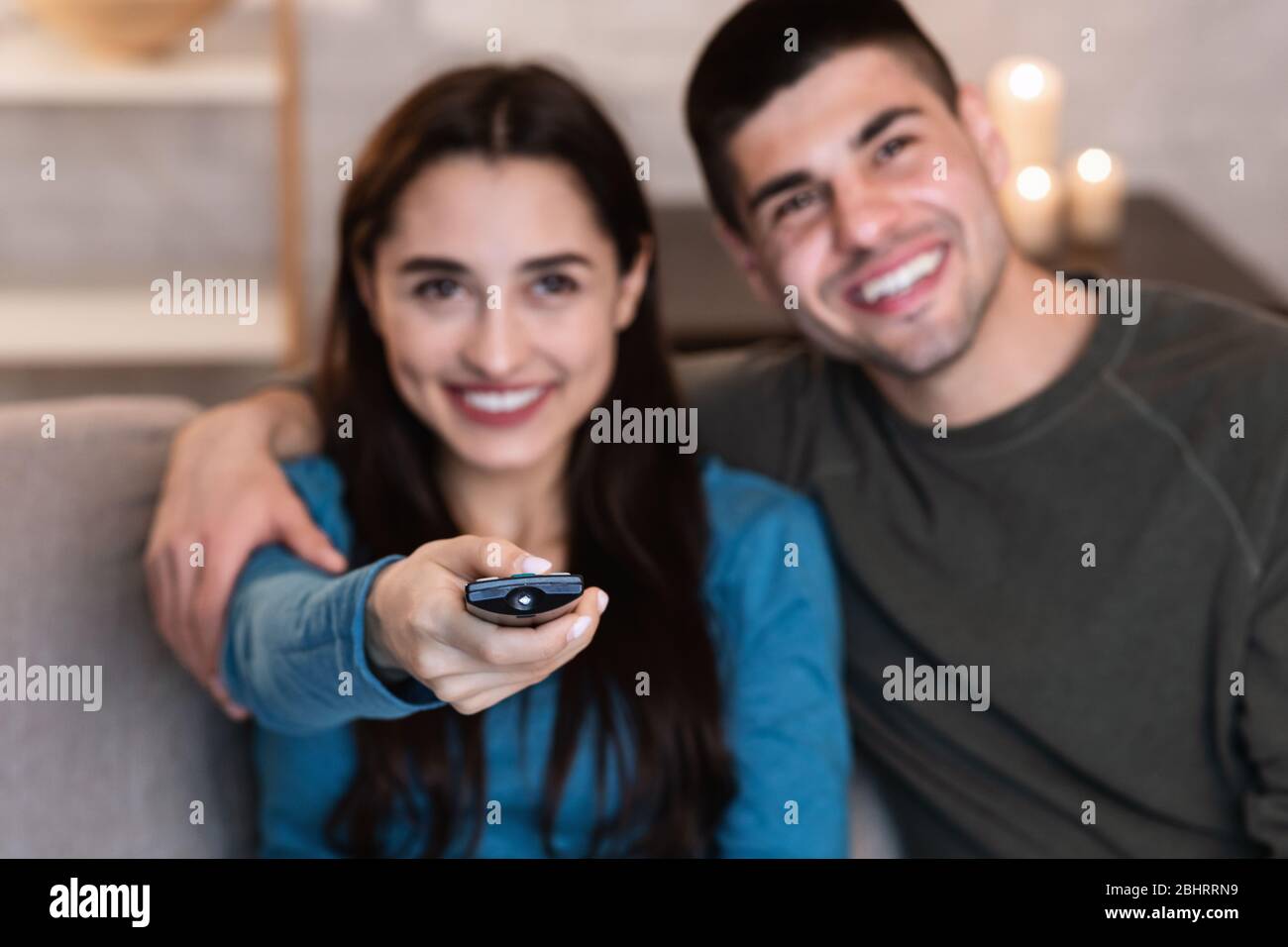 Couple sitting on couch and watching TV Stock Photo - Alamy