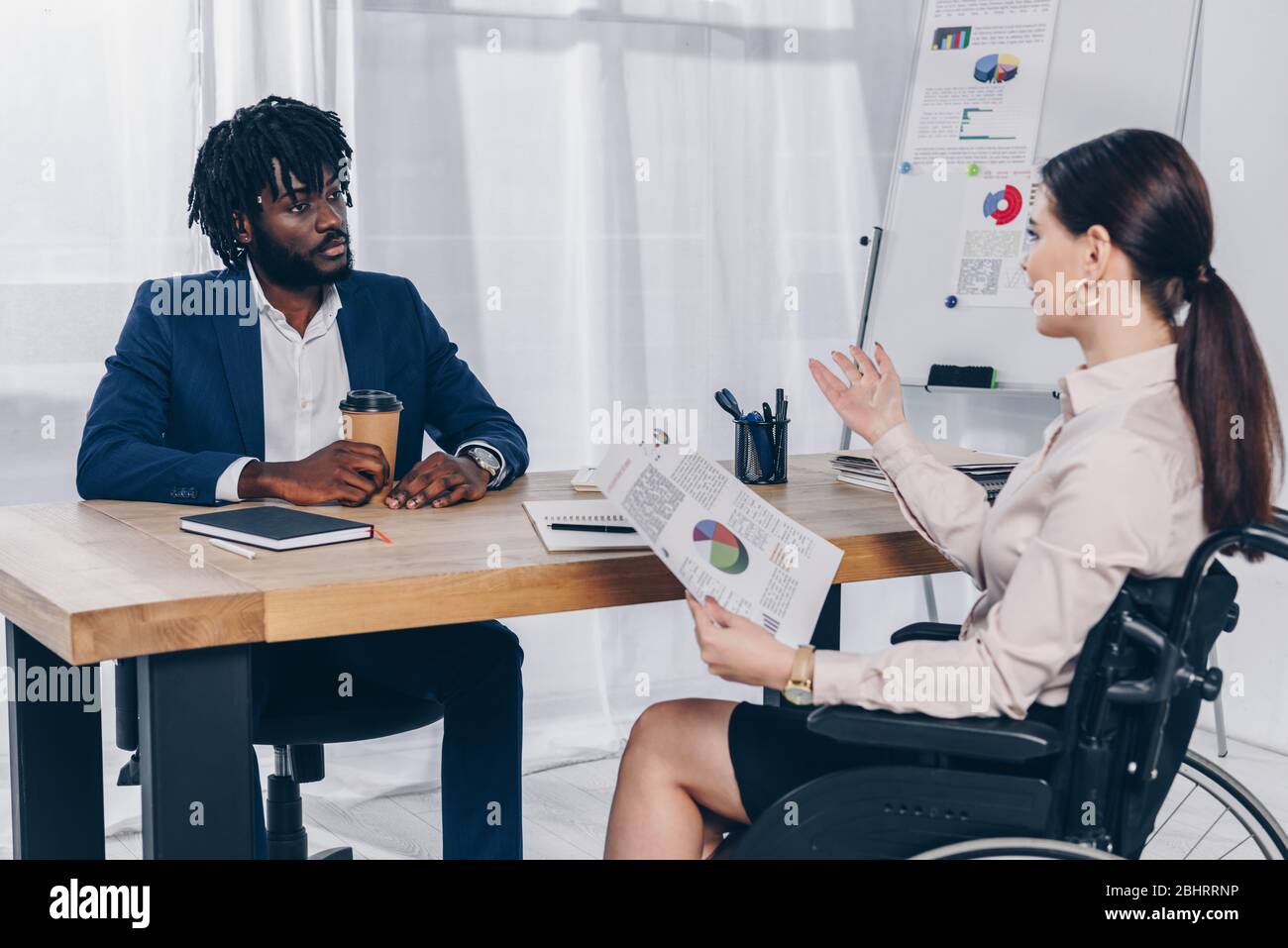 African american recruiter and disabled employee on wheelchair talking ...