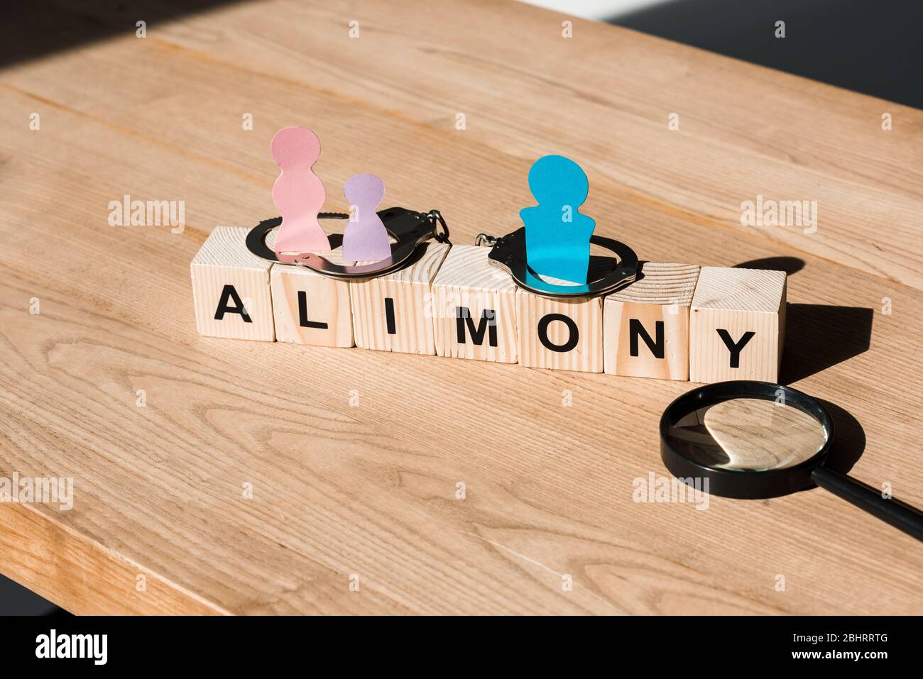 wooden blocks with alimony lettering near family paper cut, magnifier ...