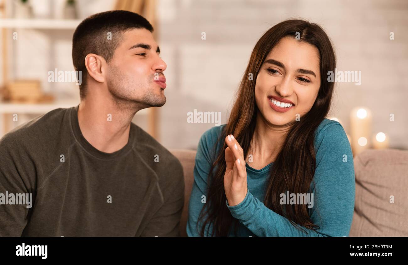 Man trying to kiss a woman, she rejecting him Stock Photo - Alamy