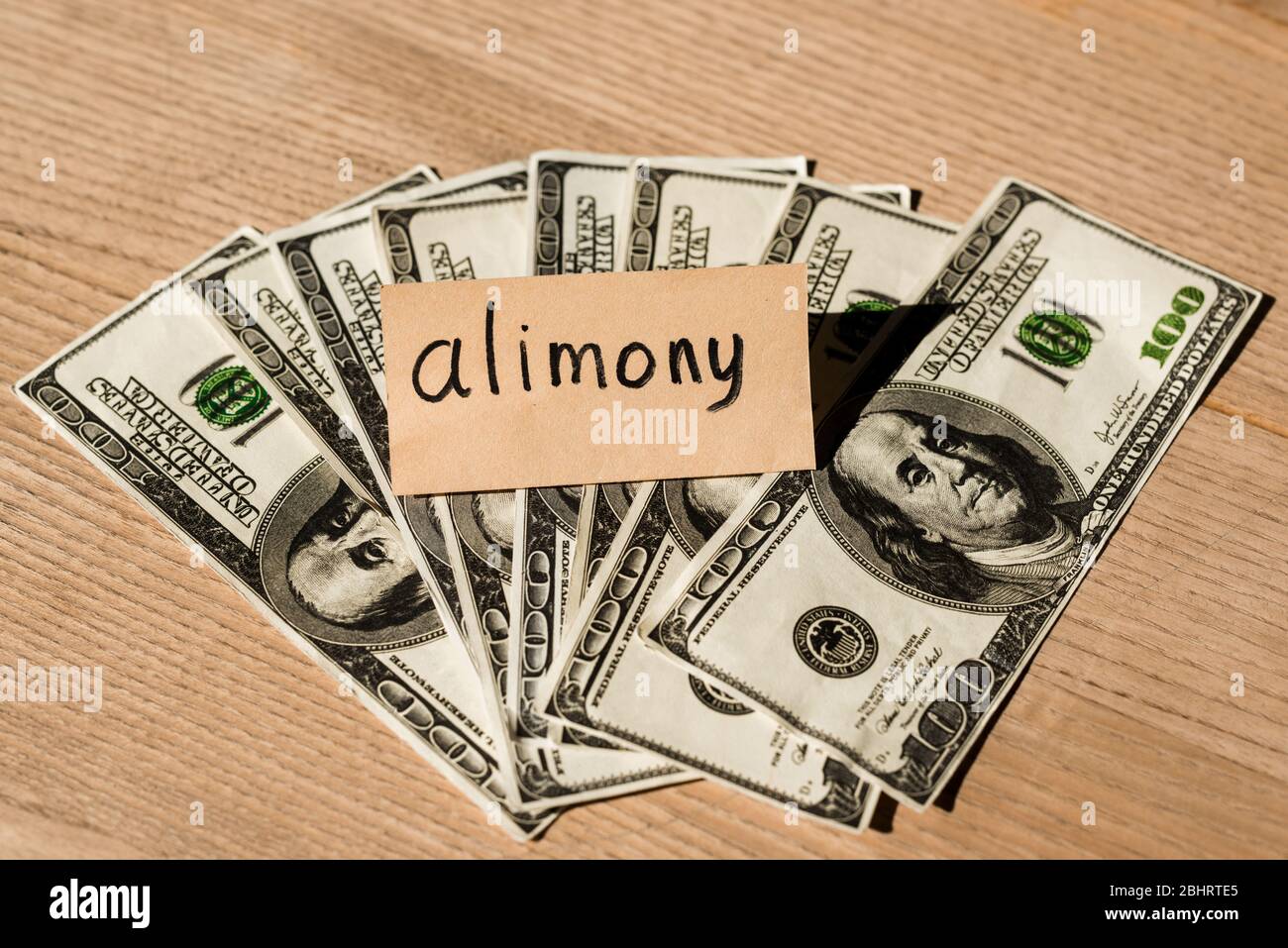 paper with alimony lettering on dollar banknotes Stock Photo - Alamy