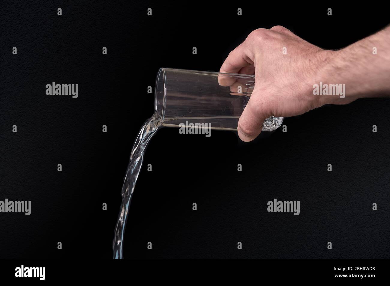 pouring stream of water from a glass on a black background Stock Photo ...
