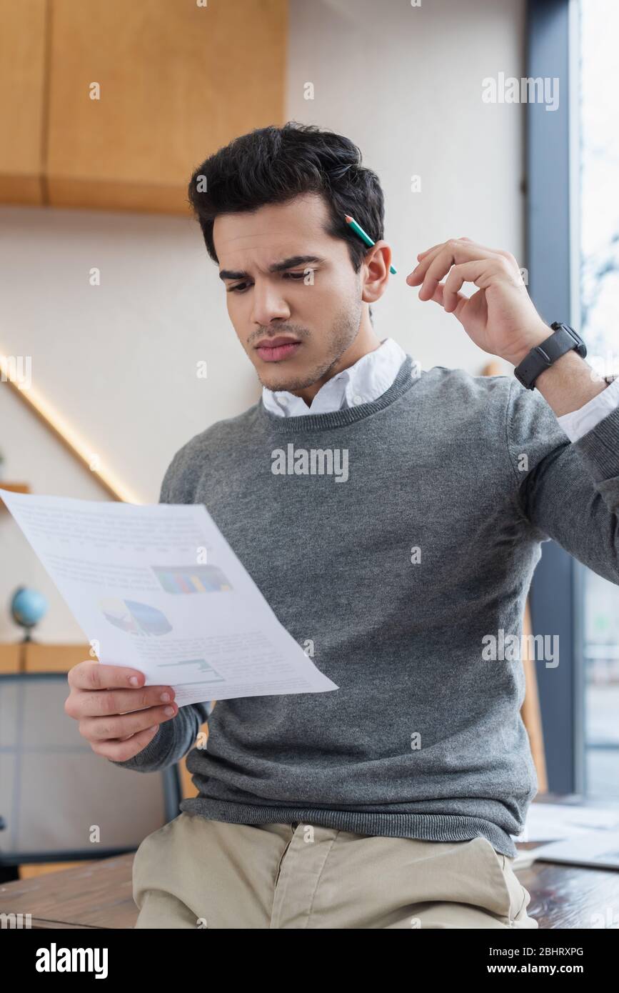 Concentrated businessman looking at paper in office Stock Photo - Alamy