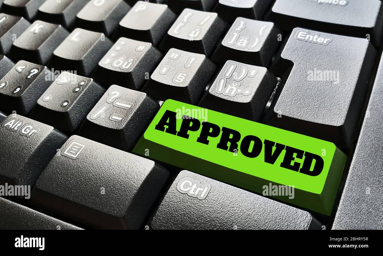 Black keyboard with one green key labeled by approved sign Stock Photo ...