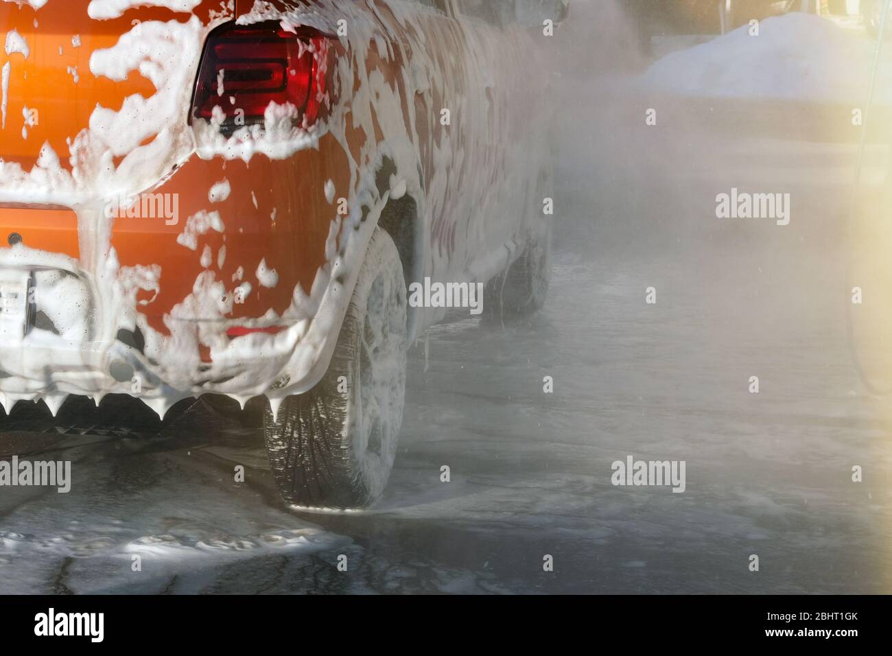 Car is cleaning with soap suds at self-service car wash. White lather ...