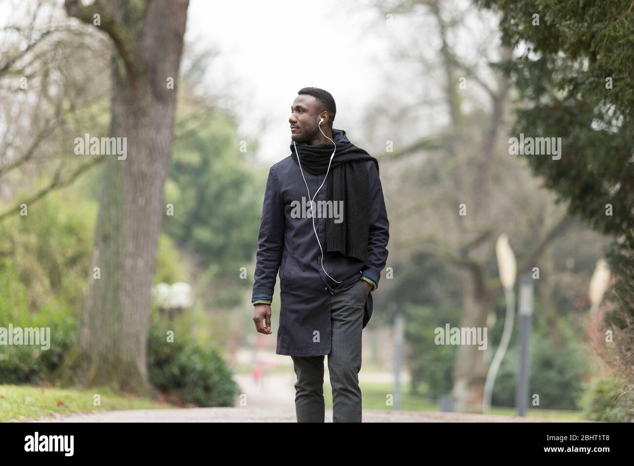 Well dress handsome black man walking in park with hand in pocket and ...