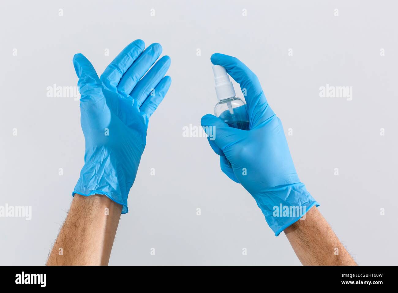 hand in rubber surgical gloves holding antiseptic hand sanitizer on ...