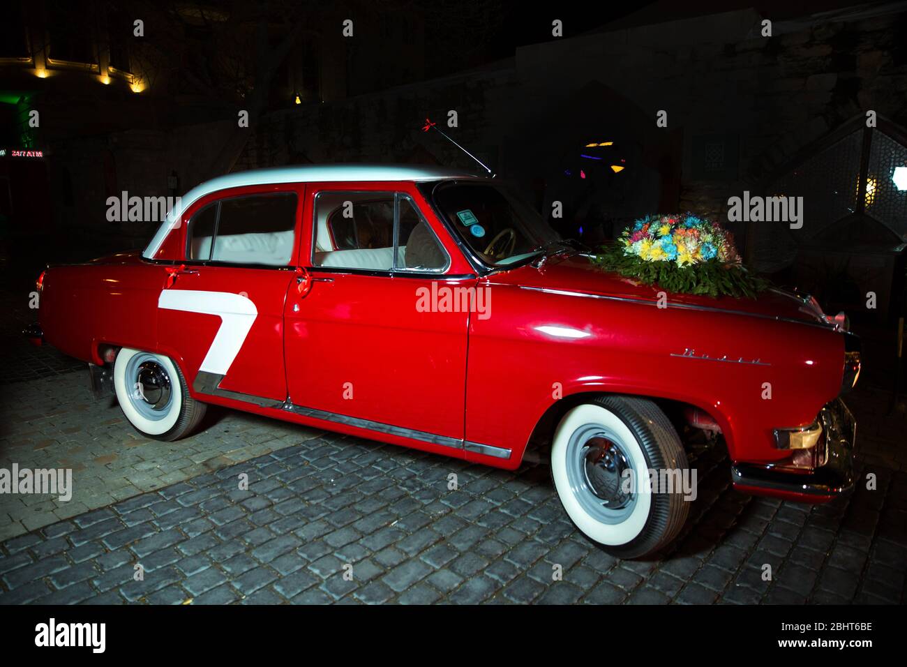 Wedding bouquet on vintage wedding car . Unusual front headlight, old ...