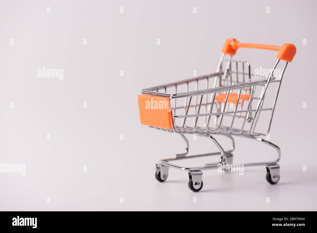 Shopping concept. Close up photo of small push cart with orange ...