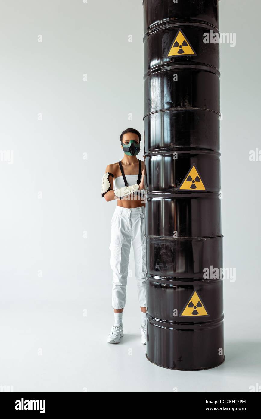 futuristic african american woman in safety mask near radioactive waste ...