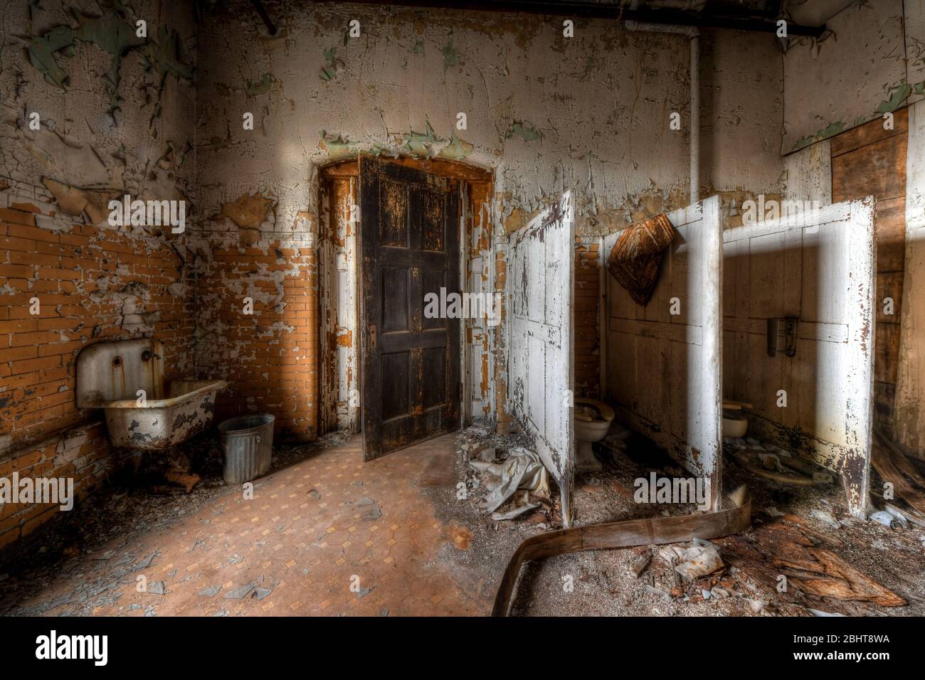 Decayed bathroom with stalls and sink in an historic abandoned hospital ...