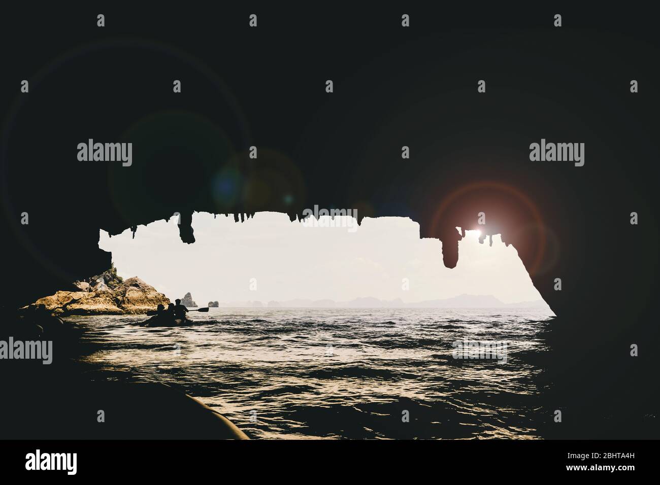 Travel and leisure concept. Dark water cave entrance illuminated by ...