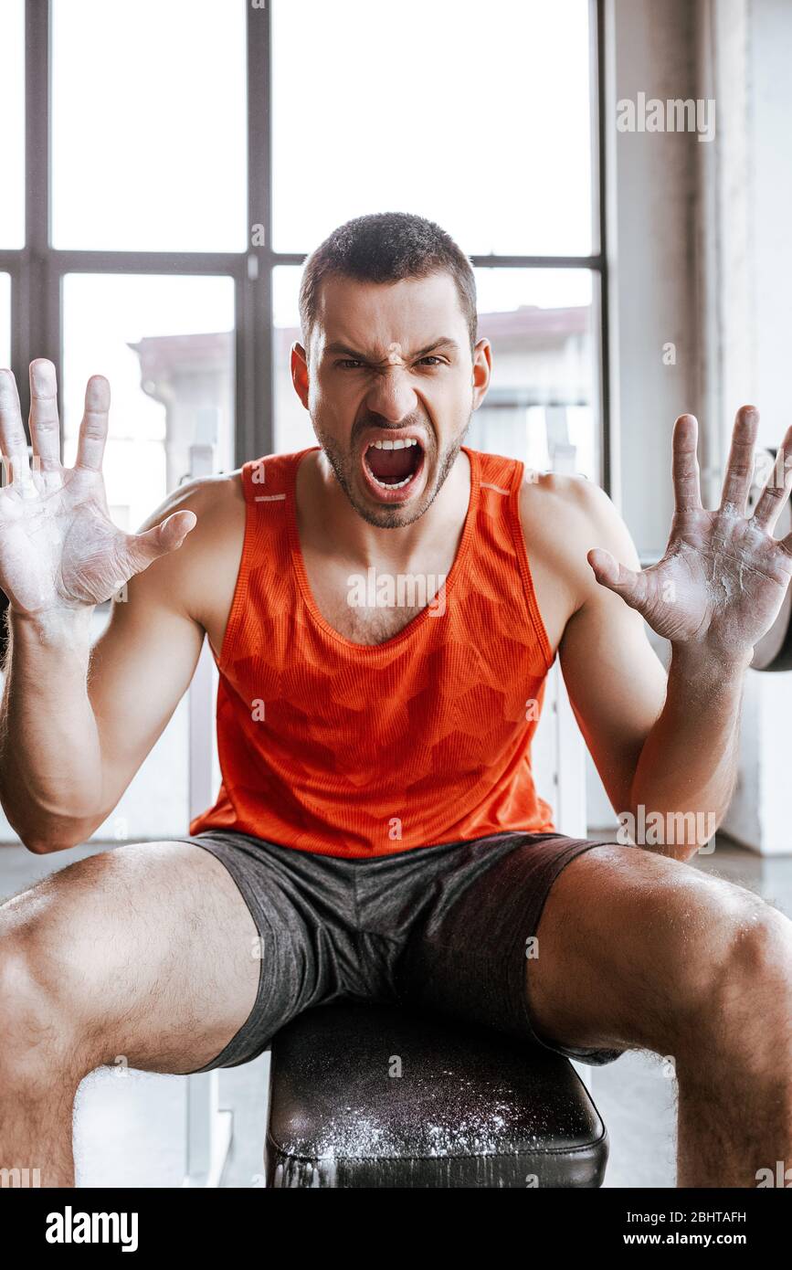 emotional handsome sportsman with white powder on hands screaming in ...