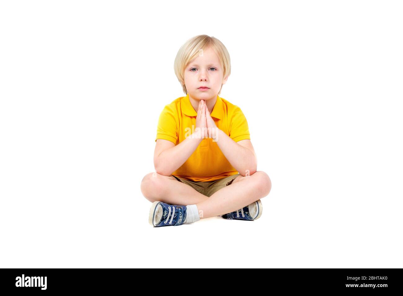Boy sitting on floor and posing isolated on white Stock Photo - Alamy
