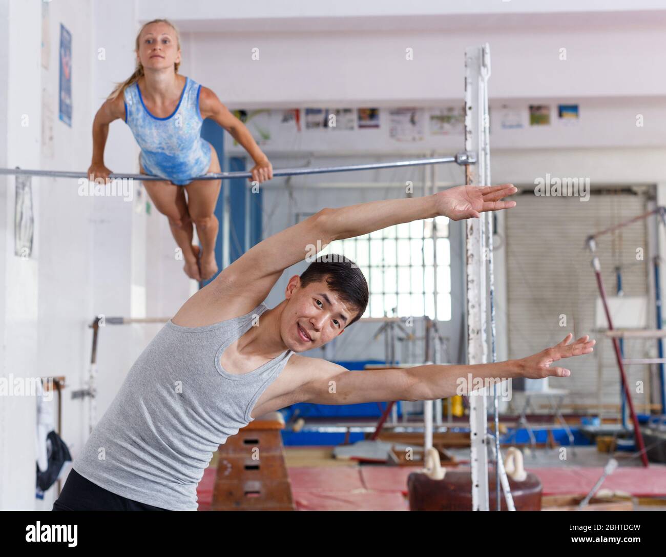 Athletic man and woman doing acrobatic exercises on floor and on ...