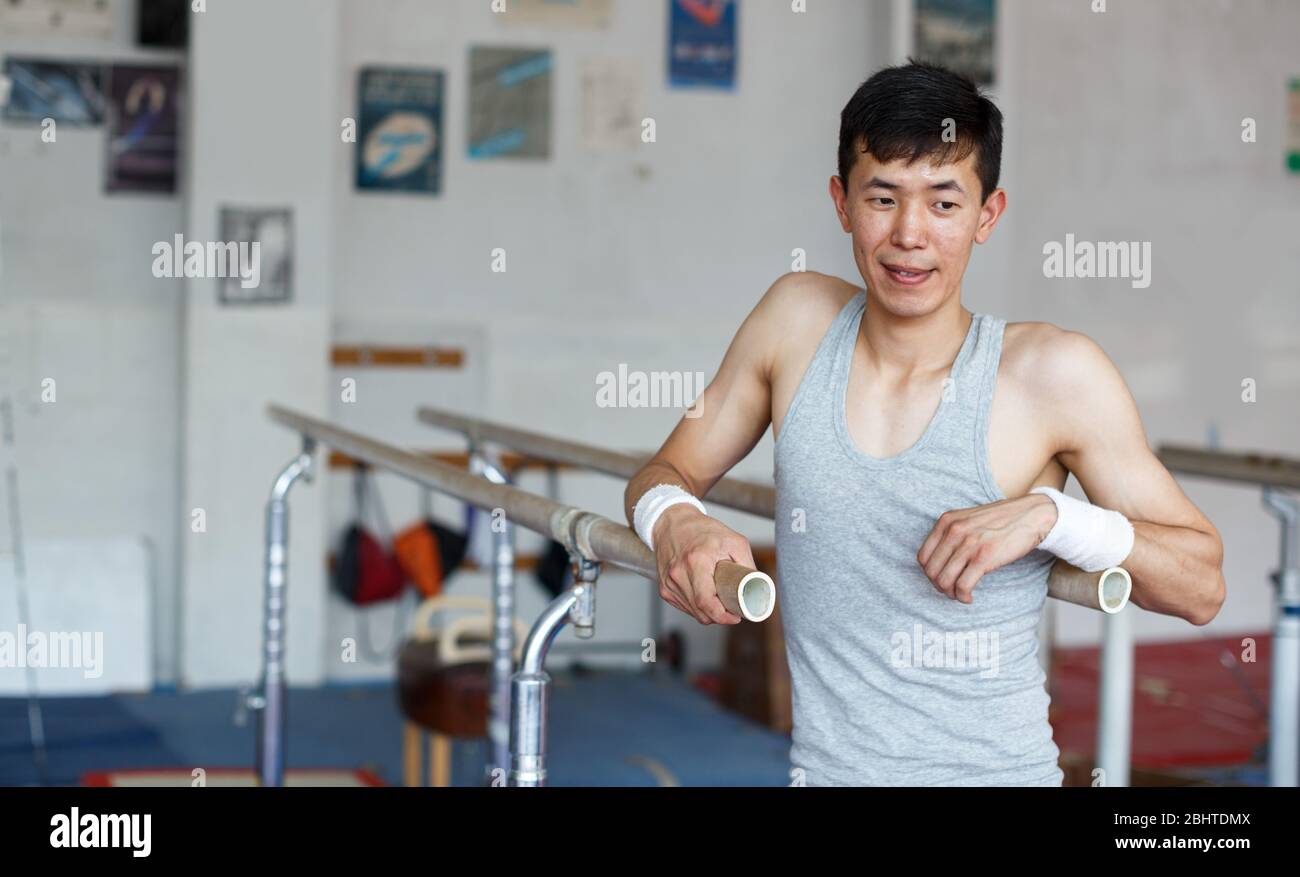 Portrait of smiling young male asian acrobat posing at sport gym Stock ...