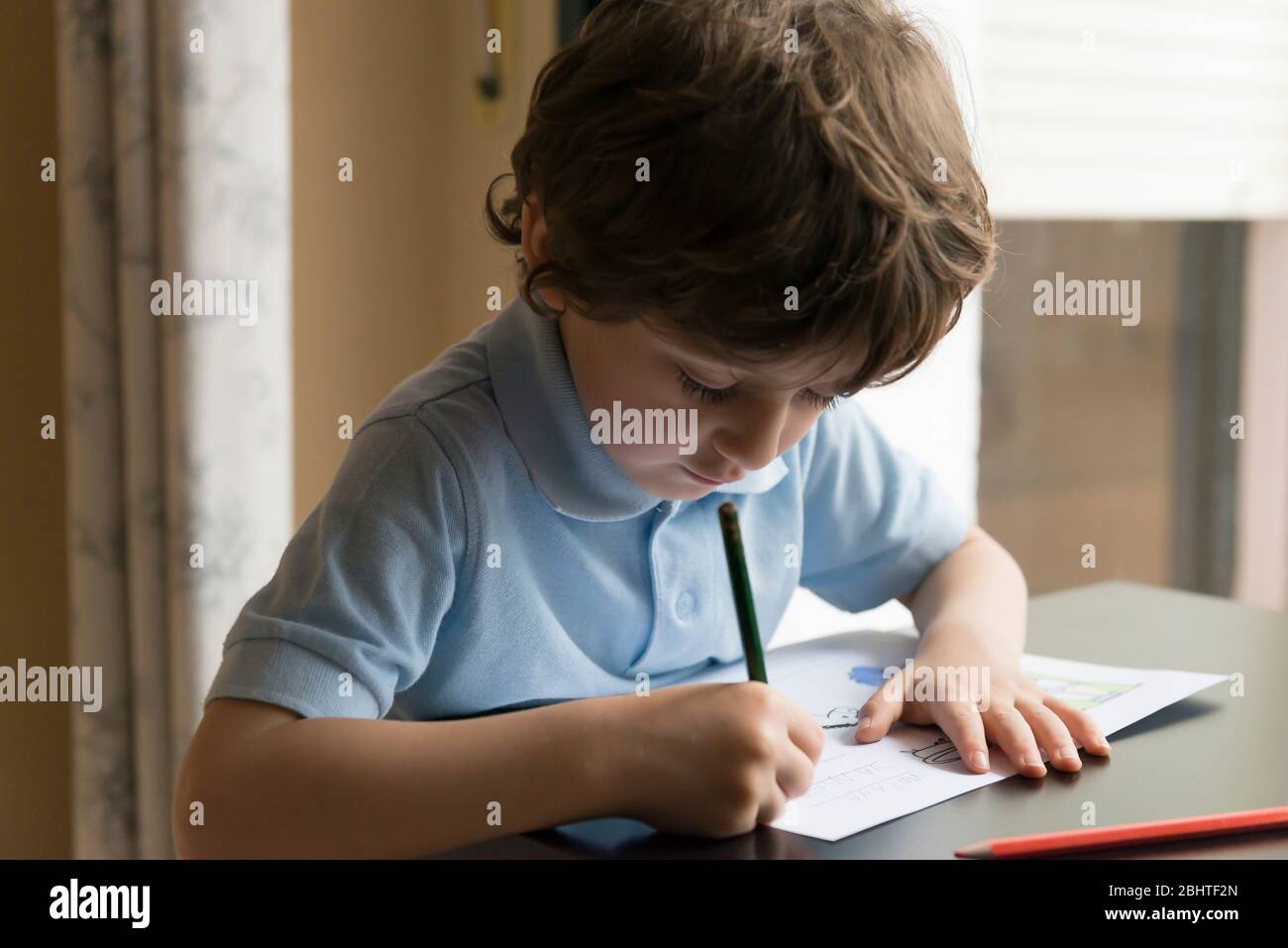 Child doing homework by a window Stock Photo - Alamy