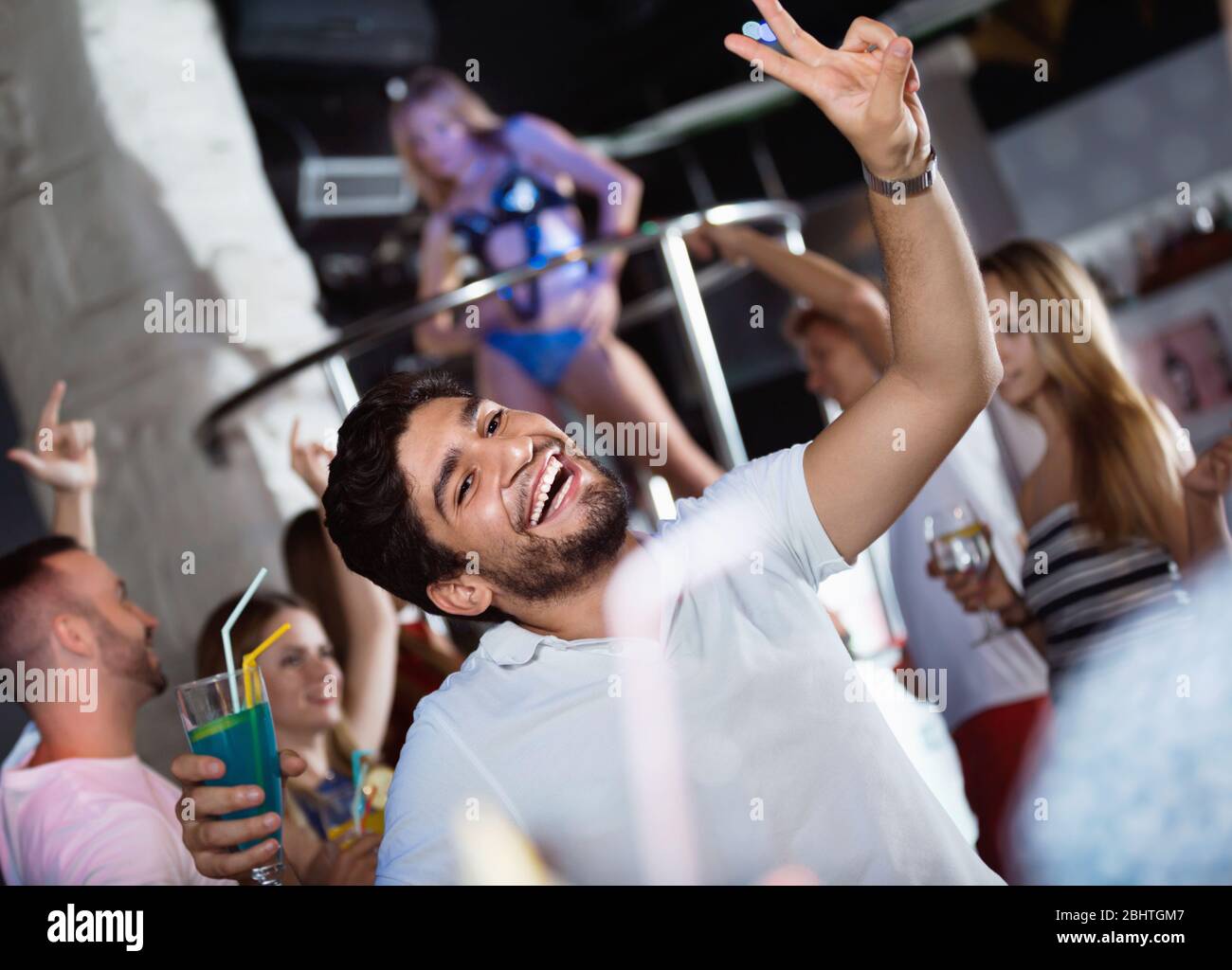 Happy cheerful smiling male joying and thumbs up on party in the club ...