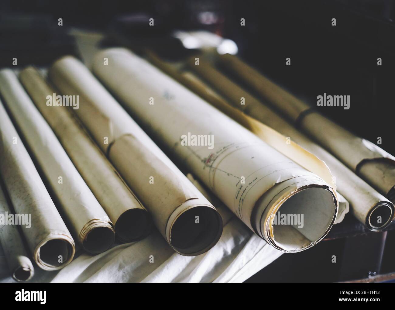 Rolled up vintage project drawings. Blurred background Stock Photo - Alamy