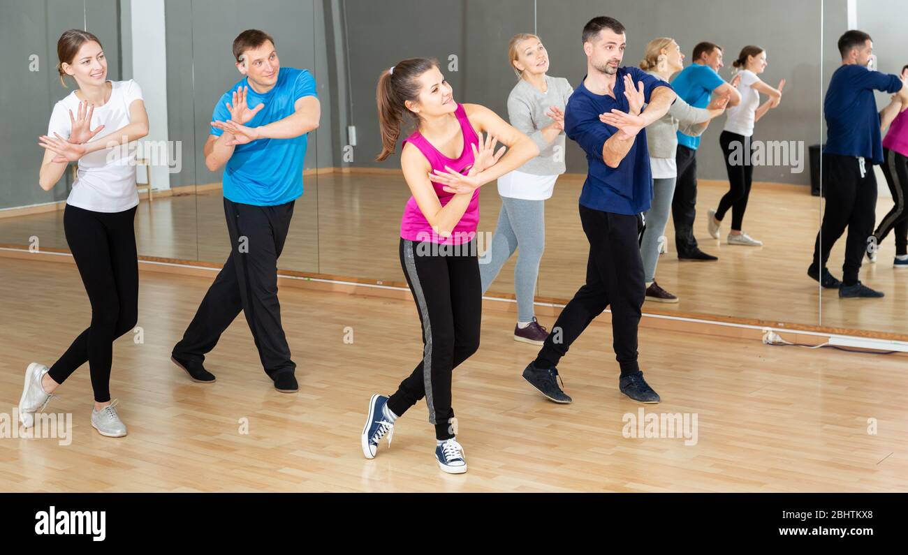 Portrait of dancing people practicing vigorous swing during group ...