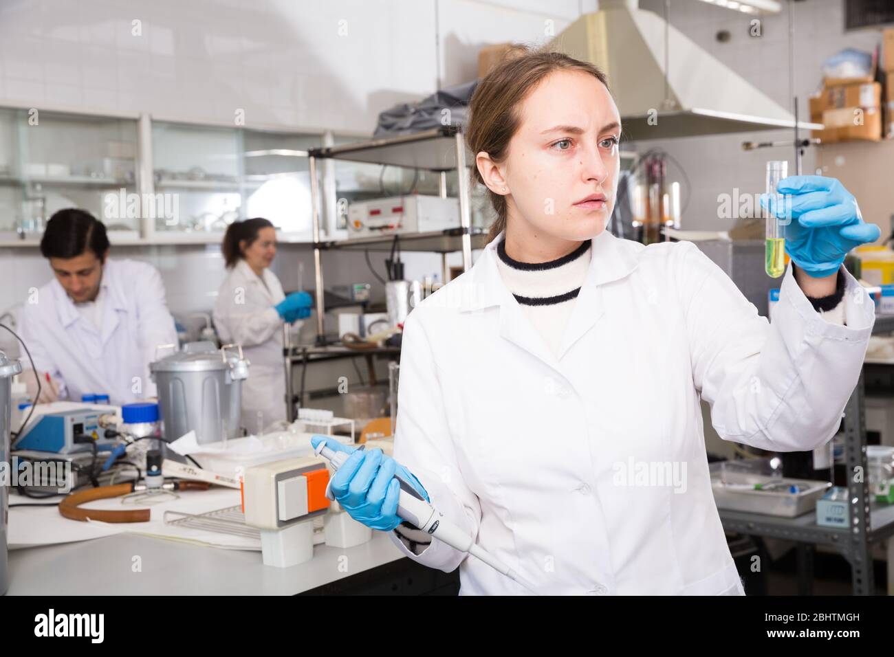 Female student performing experiments in university laboratory ...