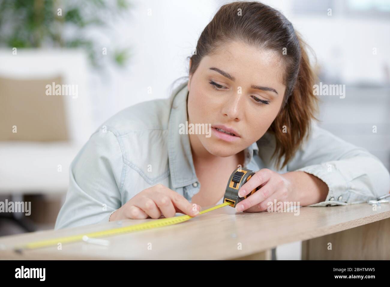 young woman using tape measure on white Stock Photo - Alamy