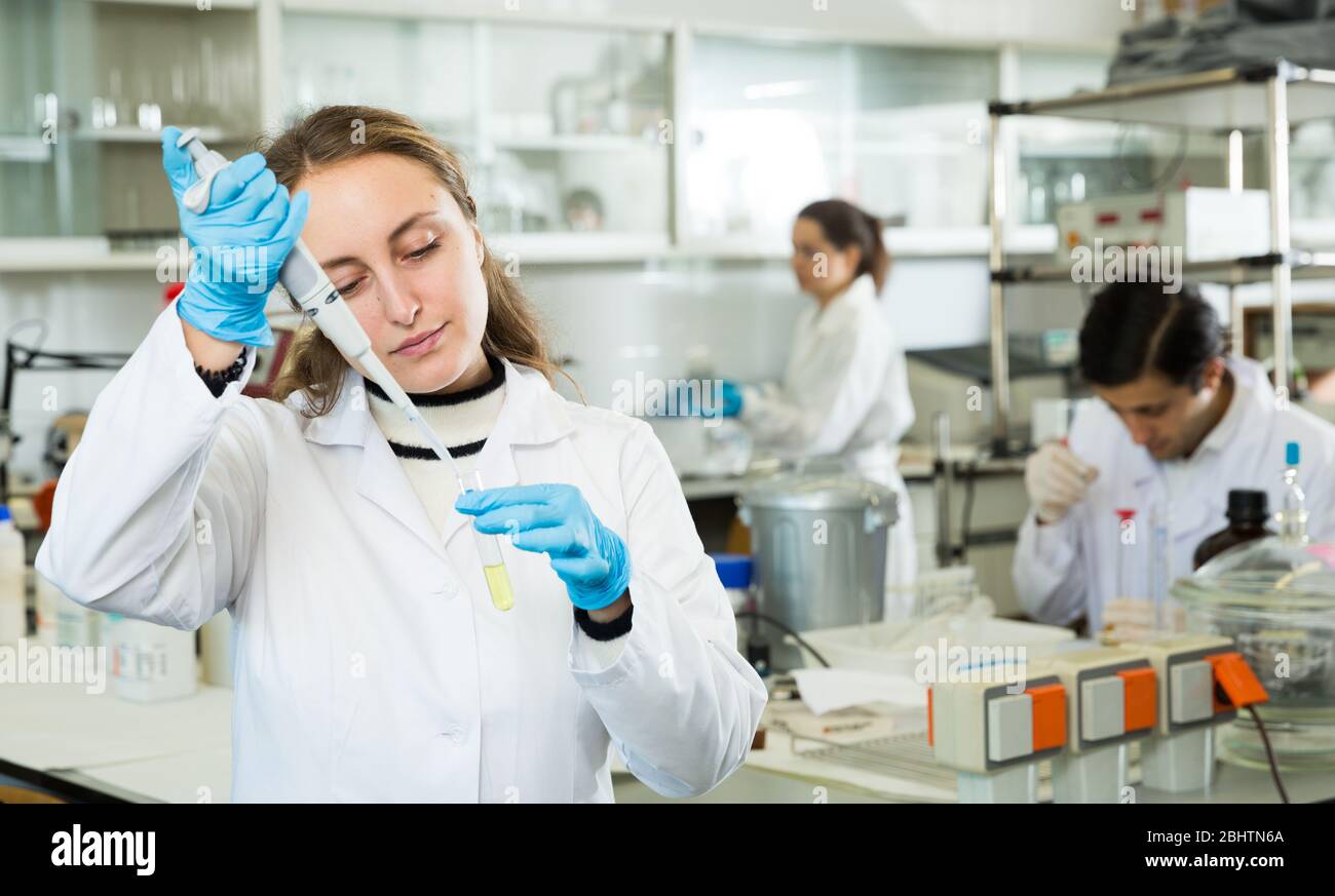Female student performing experiments in university laboratory, using ...