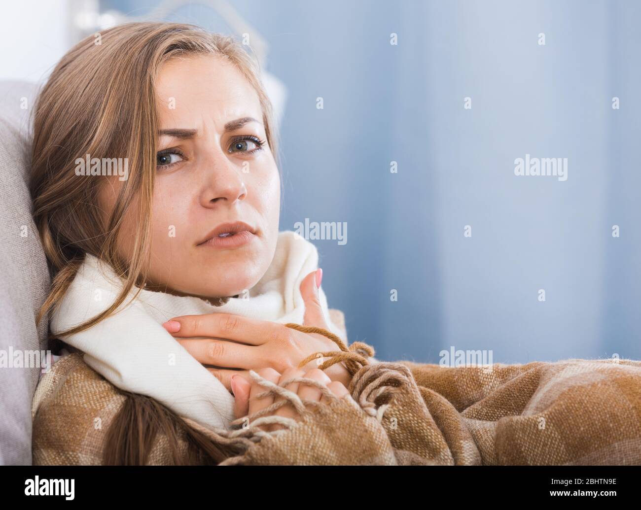 Young woman catching cold, wrapping in blanket Stock Photo - Alamy