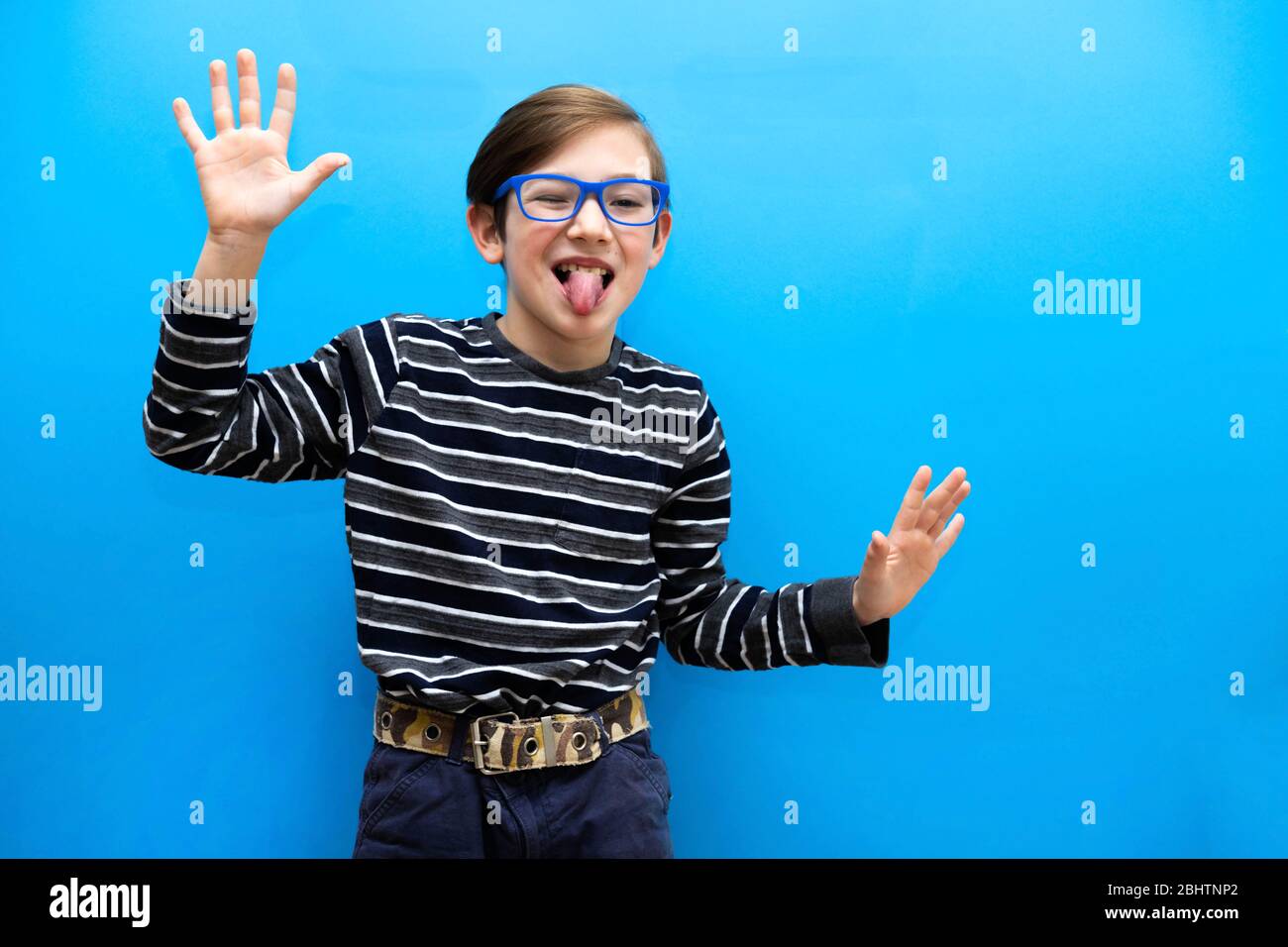 The boy is dancing and showing his tongue. A cheerful boy of 9 years ...