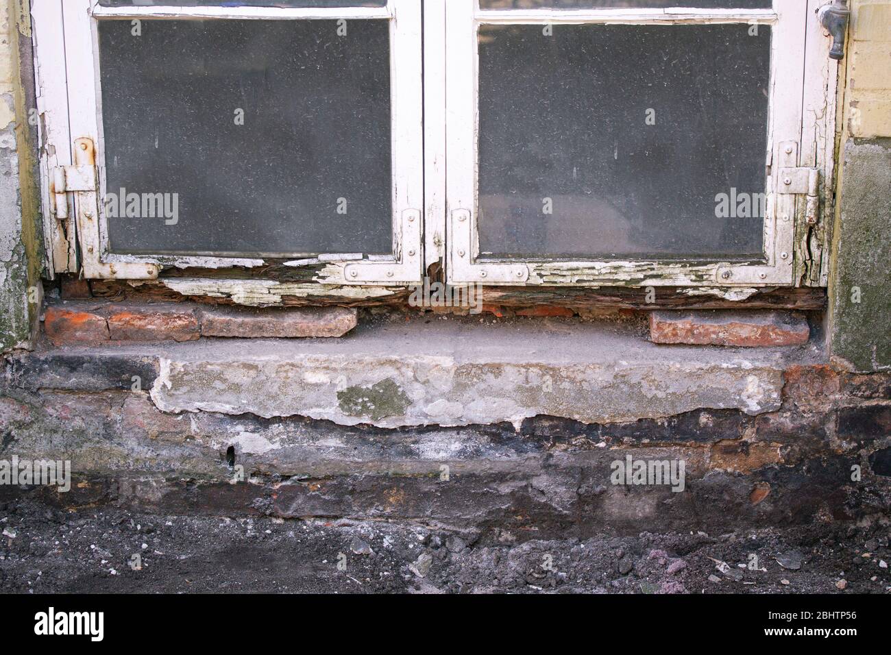 Part of the white wooden frame of an old window with peeling paint and ...