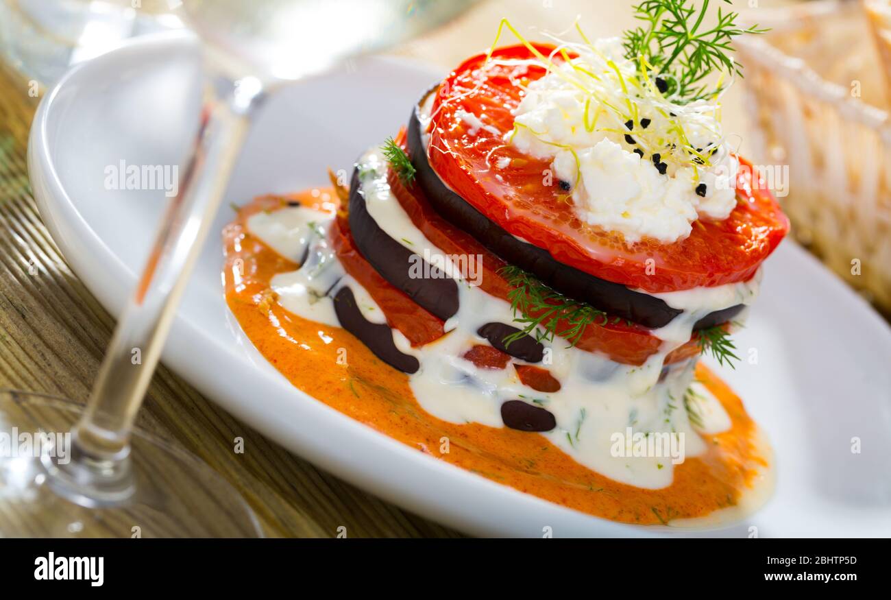 Delicious fried eggplant pyramid with tomatoes on spicy sauce with soft ...
