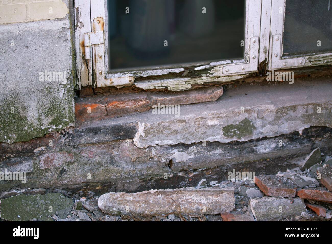 Part of the white wooden frame of an old window with peeling paint and ...
