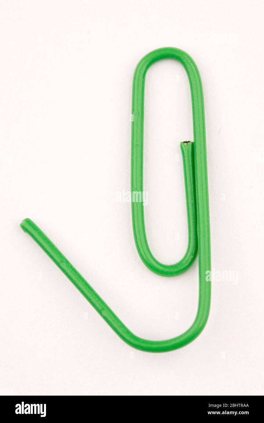 A concept photo of a closeup of a green plastic coated paper clip that ...