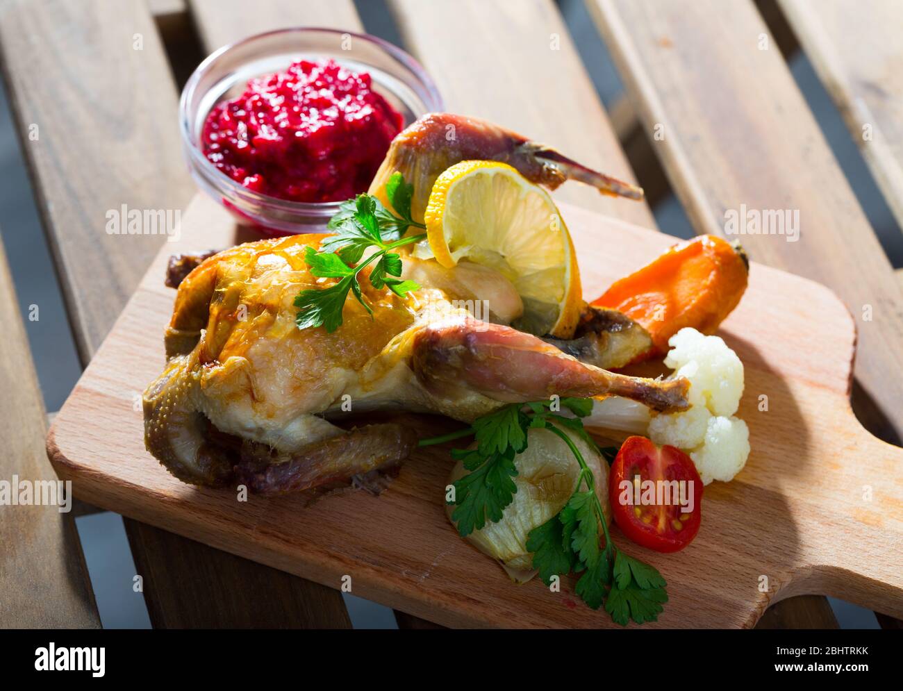 Partridge baked in oven with cranberry sauce and grilled vegetables ...