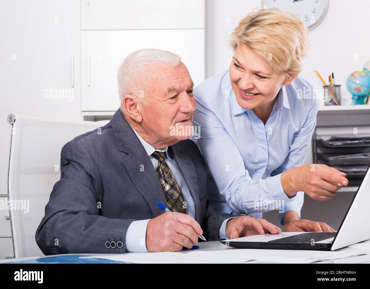 Senior manager and secretary working effectively together in office ...