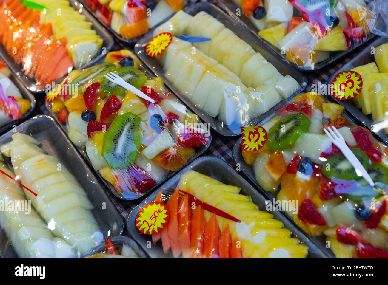 Freshly cutted assorted fruits in sets ready to eat on store showcase ...
