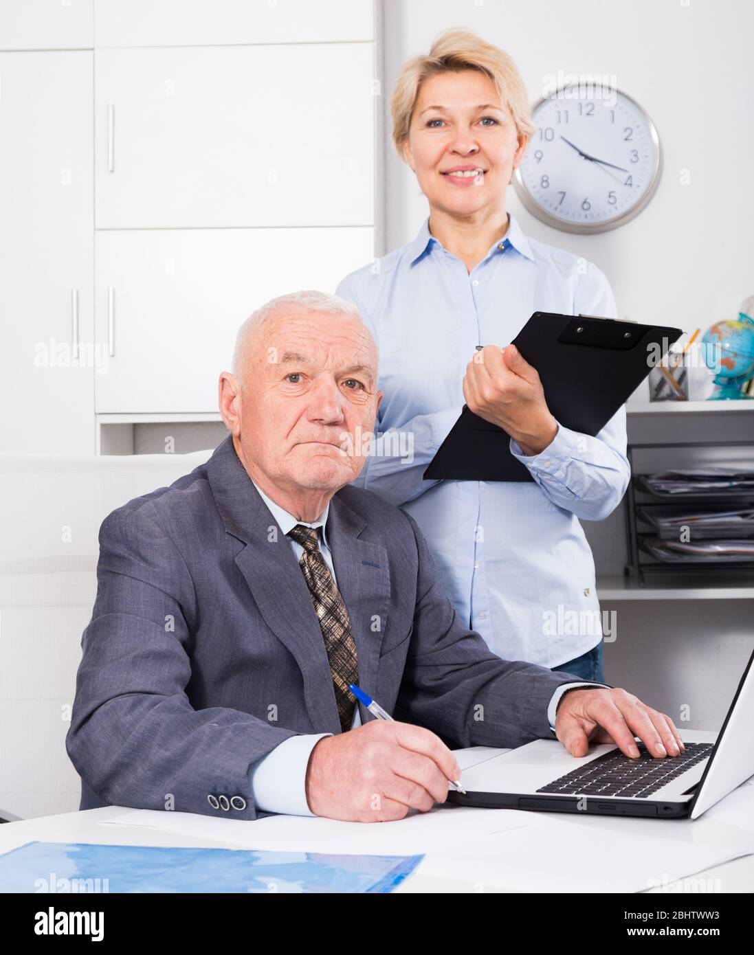 Mature manager and secretary having productive day at work in office ...