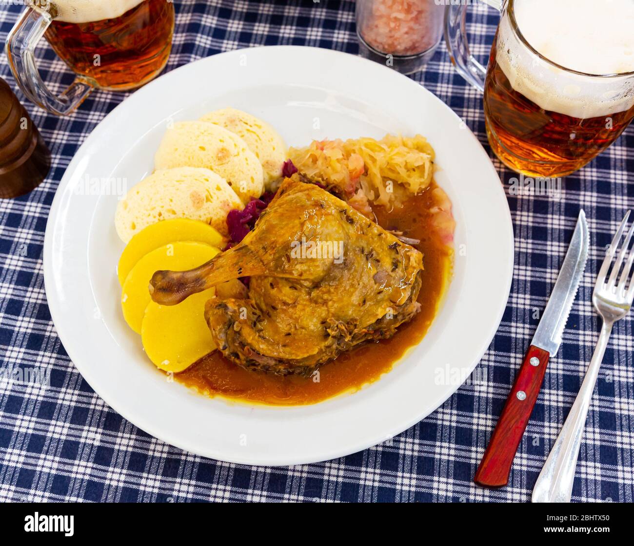 Roasted quarter duck with red and white cabbage, bread and potato ...