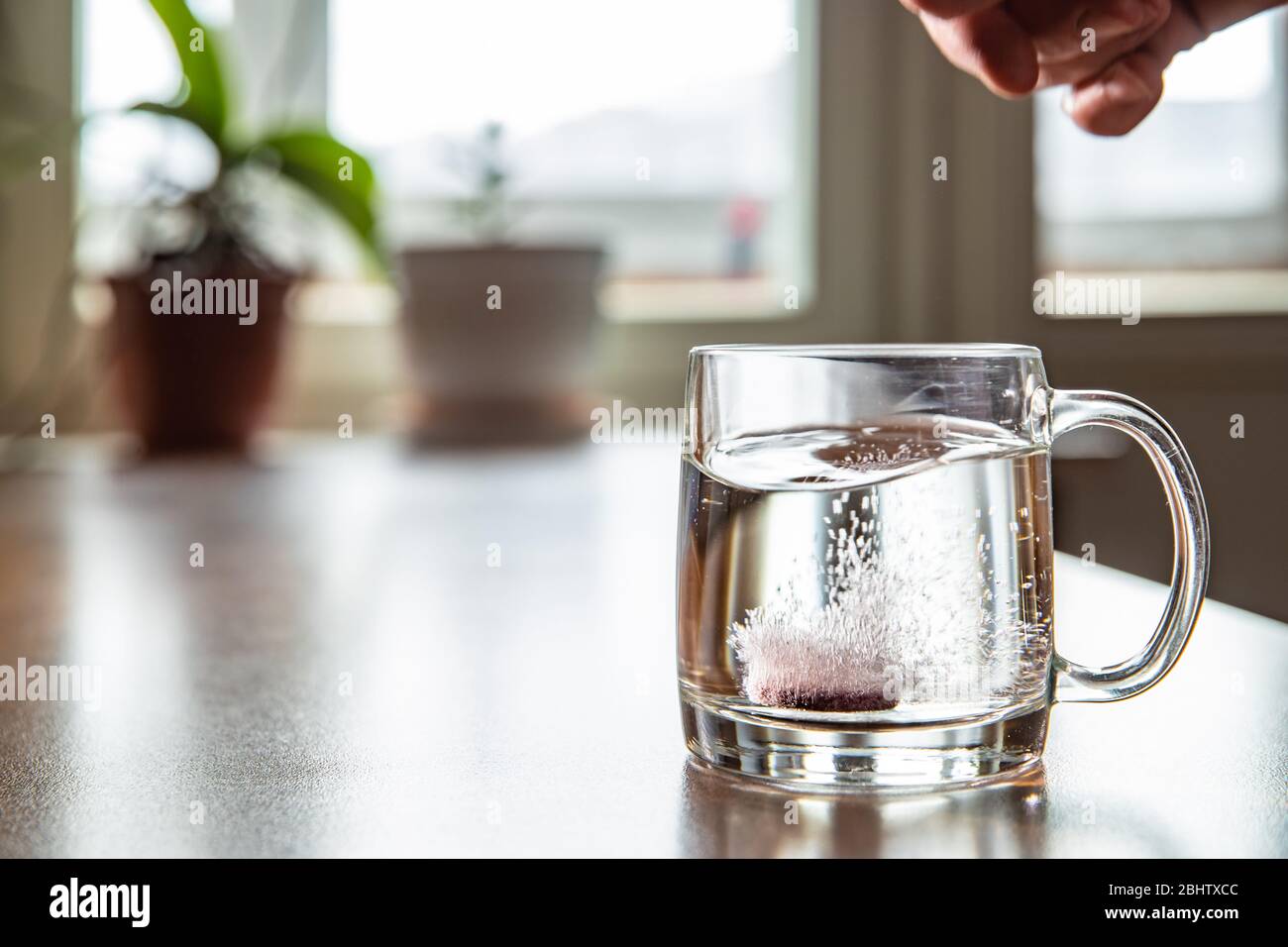 Sparkling tablet throw into a glass transparent glass, the glass is on ...
