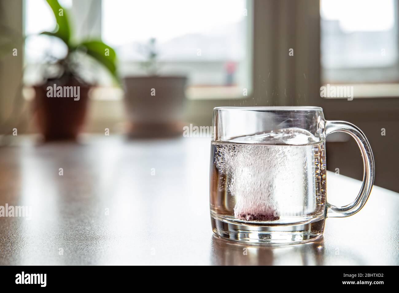 Sparkling tablet throw into a glass transparent glass, the glass is on ...