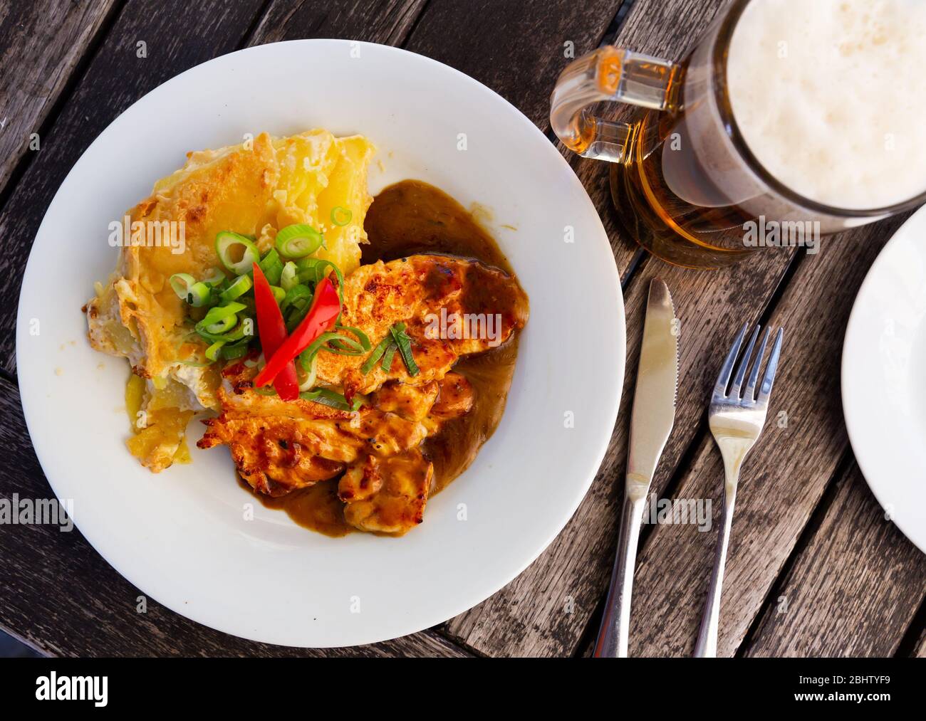 Czech dish - chicken with baked potato served with sauce and greens ...