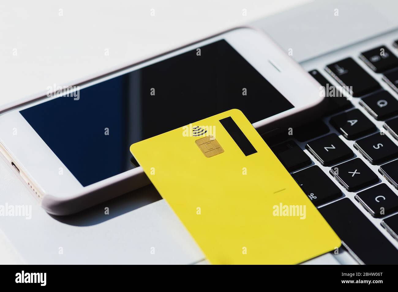 yellow credit card, laptop keyboard, smartphone on white background ...