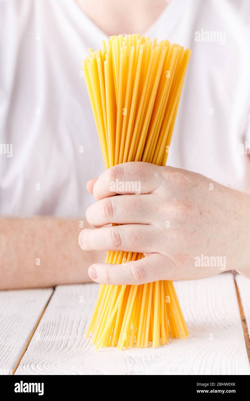 Hand full of raw dry spaghetti, close up view Stock Photo - Alamy