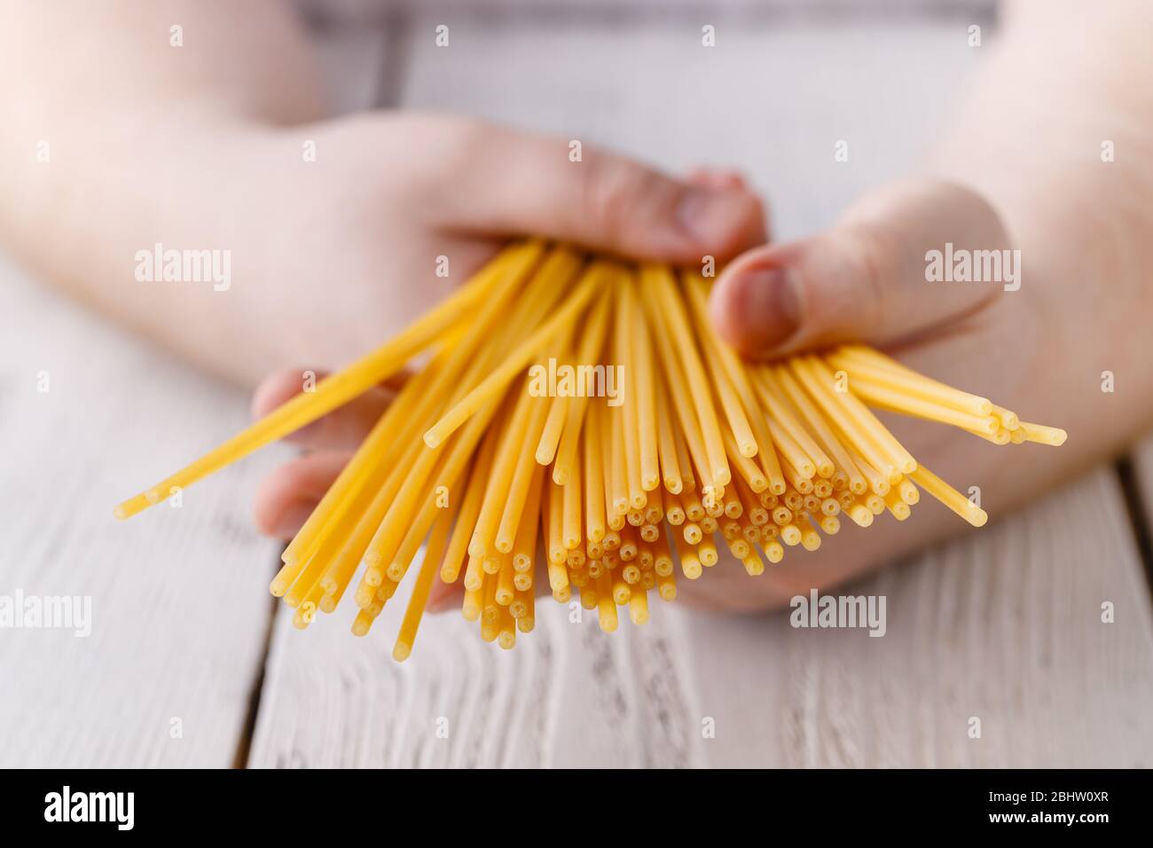 hands holding spaghetti in the kitchen Stock Photo - Alamy