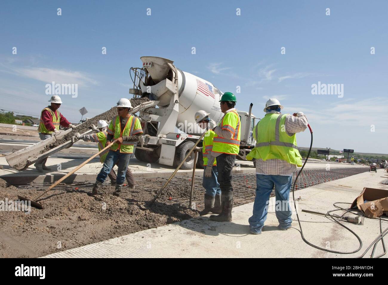 Austin Texas USA, April 6, 2011:Workers pour concrete onto roadway ...