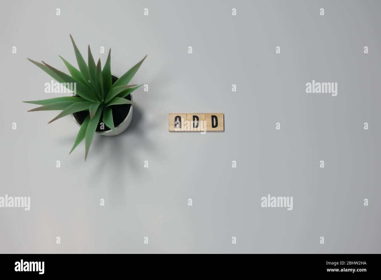 The word Add is written in wooden letter tiles on a white background ...