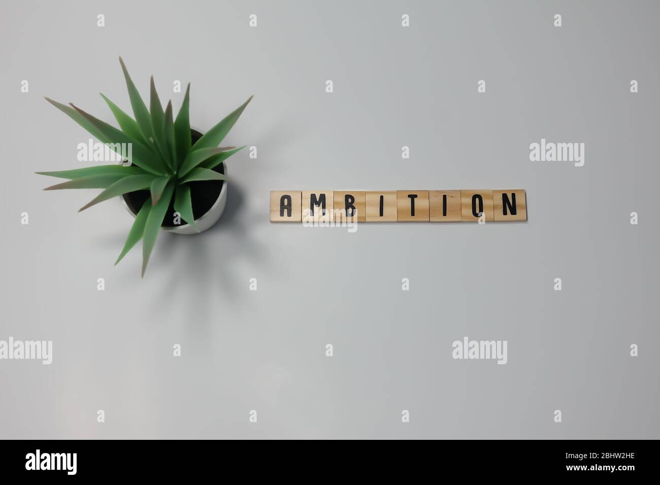 The word Ambition written in wooden letter tiles on a white background ...